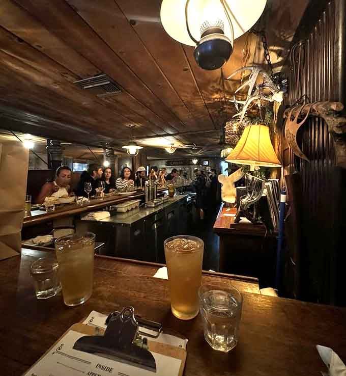 The bar glows with vintage lighting while diners enjoy drinks in this genuinely historic setting.