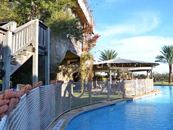 The pool stretches across the grounds with that thatched bar waiting patiently for your poolside beverage orders.