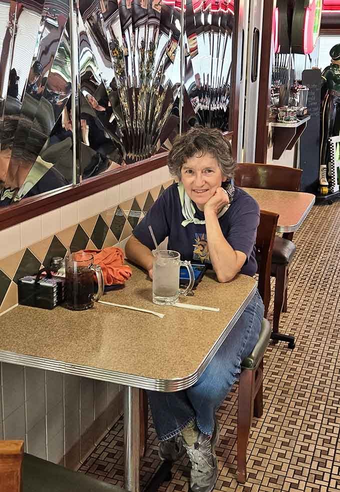 A happy customer settles into her booth, surrounded by retro details that transport you straight to simpler times.