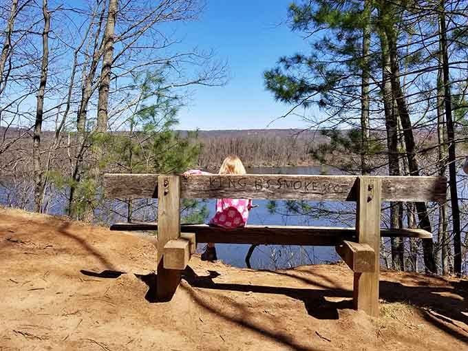 Someone carved "Smoke Spot" into this bench, proving nature lovers have excellent taste in real estate.