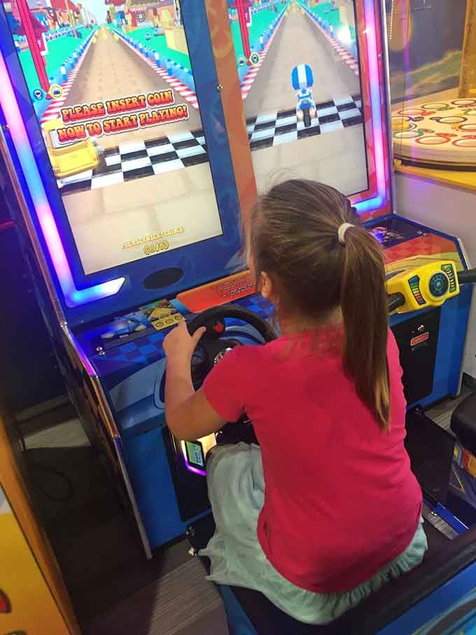 She's mastering that racing game with the focus of someone who definitely doesn't have a driver's license yet.