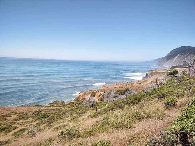 Green hillsides meet endless blue ocean in views that justify every challenging switchback getting here.
