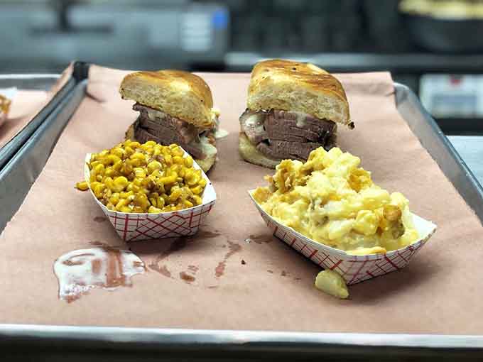 Brisket sliders with cheesy corn and mac and cheese represent the holy trinity of barbecue side dish excellence.