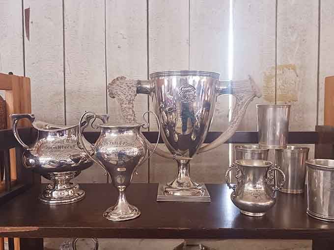 Silver trophies and serving pieces gleam with the kind of elegance that made dinner parties legendary back in the day.