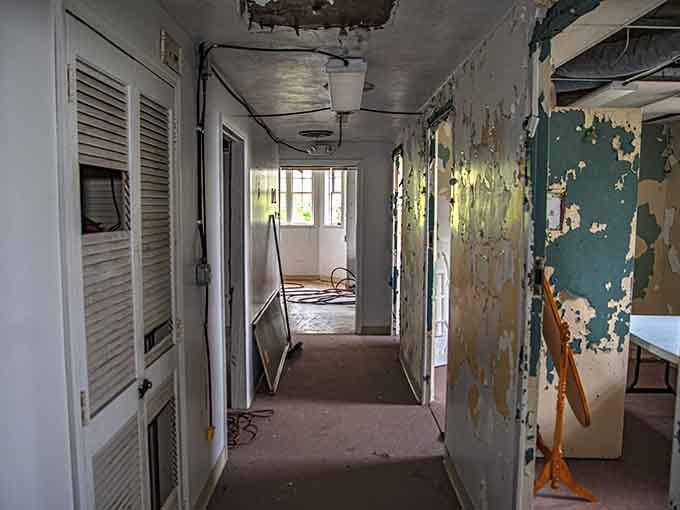 Peeling paint in shades of institutional green and yellow line corridors where countless souls once walked daily.