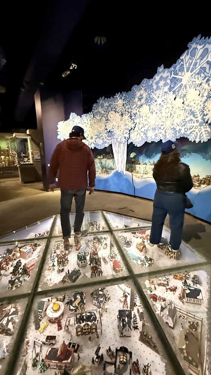 Visitors peer down at a winter wonderland village, discovering new details with every passing moment together.
