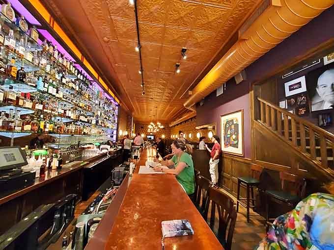 That gleaming bar stretching into the distance holds more spirits than a Dickens novel and twice the charm.