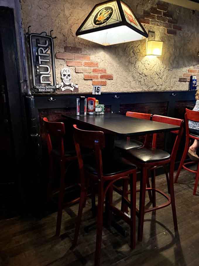 Exposed brick walls and skull decorations create a booth experience that's equal parts cozy tavern and delightfully macabre museum.