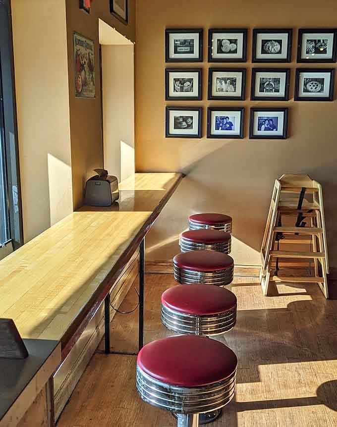 Window-side seating with framed memories adorning warm walls creates the perfect pie-eating atmosphere.