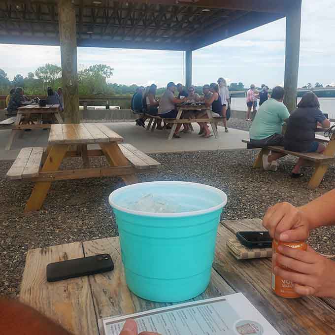 Picnic tables facing the river where the seafood tastes better and conversations somehow flow easier than anywhere else.