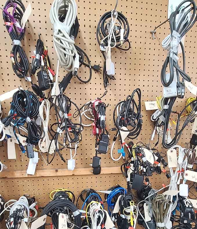 Cables and chargers hang like technological spaghetti, each one potentially the exact cord you've been searching for since 2015.