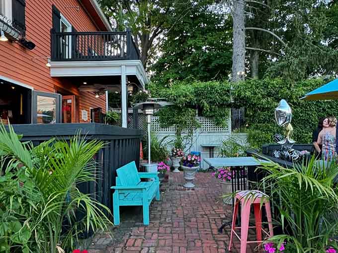 Brick pathways winding through turquoise chairs and lush greenery, this patio feels like someone's secret garden in Mexico.