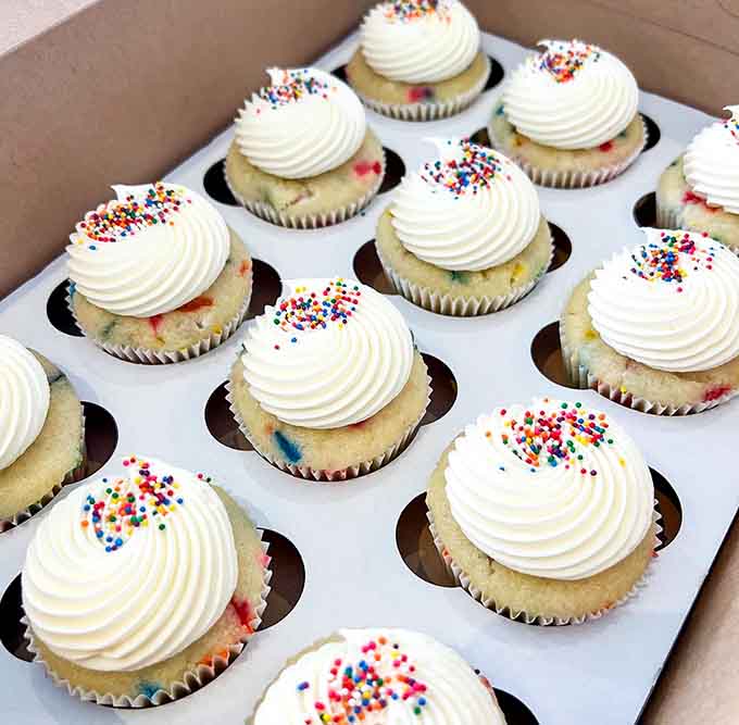 Classic vanilla cupcakes with generous frosting swirls and rainbow sprinkles prove that sometimes simple done right is exactly what your sweet tooth is craving.