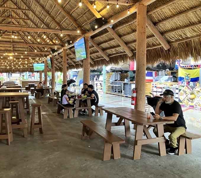 The food court's thatched roof and wooden benches make eating feel like a tropical vacation activity.