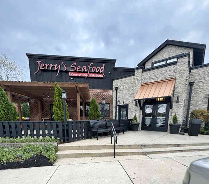 The outdoor patio beckons with greenery and umbrellas, inviting you to savor crab cakes in a relaxed, welcoming setting.