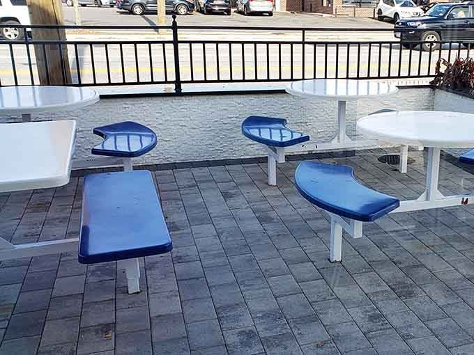 Blue seats, white tables, and open sky above, the outdoor patio at All American is where good meals become great memories.