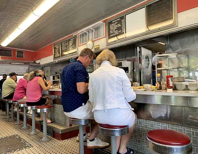 The counter crowd knows this is where the real action happens, front row to breakfast theater.