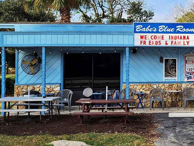Outdoor seating with palm trees and picnic tables, because sometimes Florida weather demands al fresco dining.