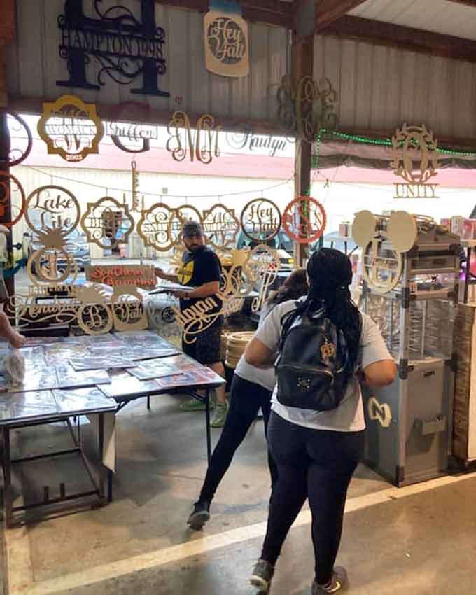 Shoppers browsing personalized wooden signs, because everyone needs their name on something decorative.