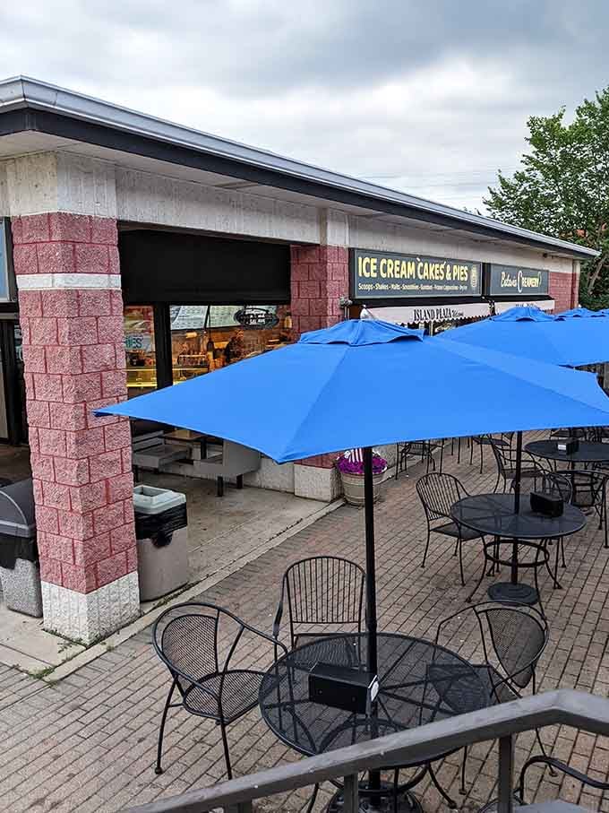 Blue umbrellas provide shade for outdoor seating where you can enjoy your treats without melting faster than them.