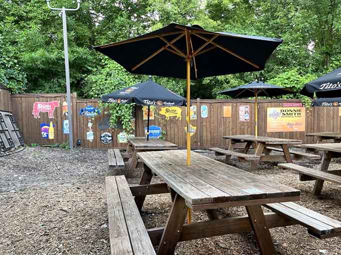 Outdoor picnic tables under umbrellas offer the classic barbecue experience, perfect for summer evenings and smoky aromas drifting by.