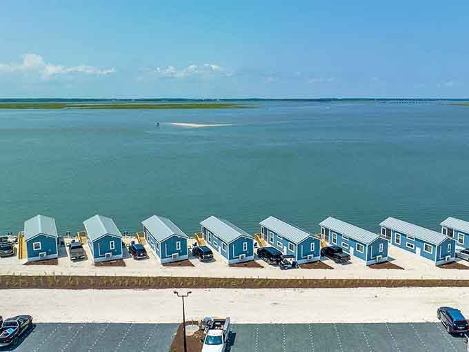 Aerial view shows the brilliant blue bungalows against the water, like a postcard come to life.