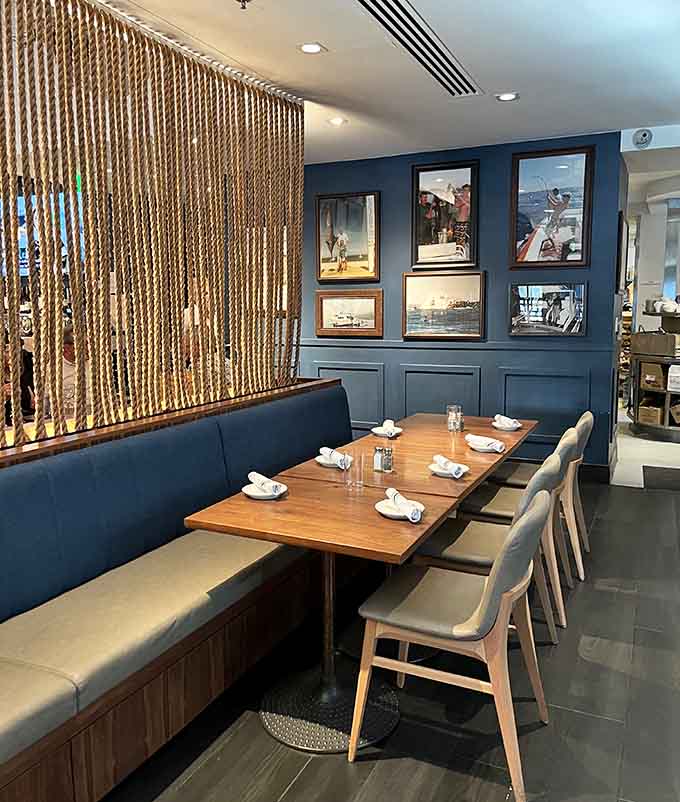 Cozy booths and nautical artwork create an inviting atmosphere that feels both sophisticated and welcoming simultaneously.