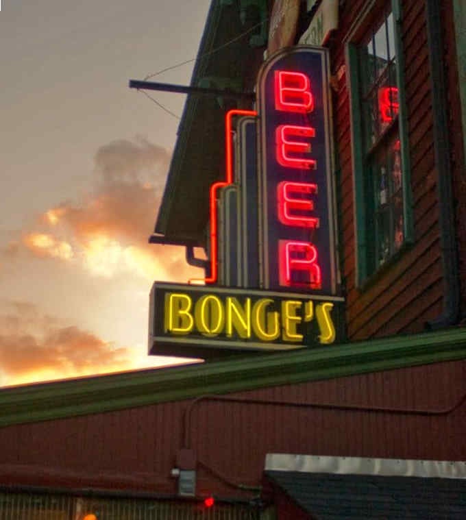 That glowing neon sign cuts through the twilight like a beacon for hungry travelers seeking salvation.