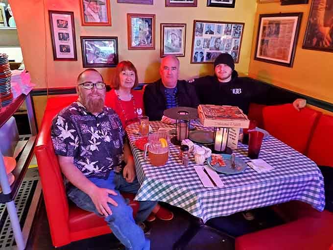 Generations gather around red booths where conversations flow as freely as the laughter and cheese pulls.