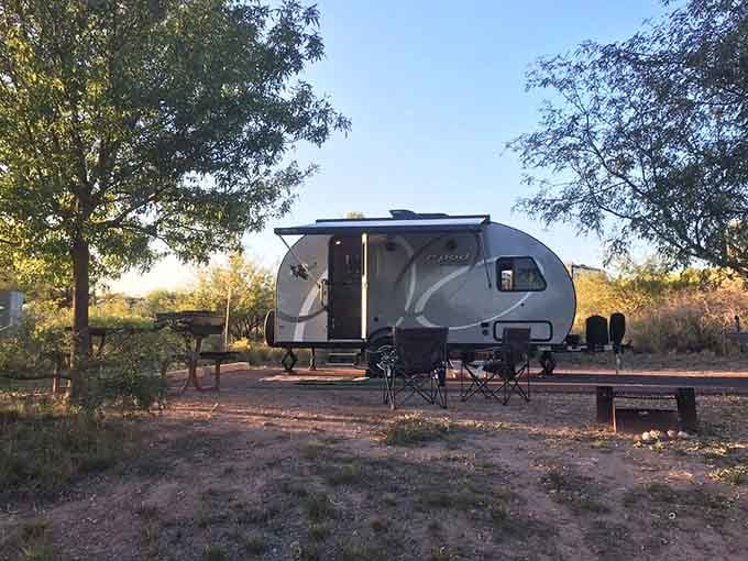 RV campsites nestle under towering trees, offering that rare Arizona camping experience where shade is abundant and heat is manageable.