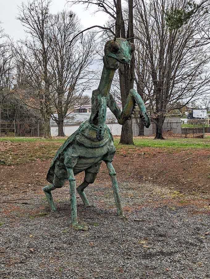 A praying mantis statue towers overhead, because why should dinosaurs have all the fun in this forest?