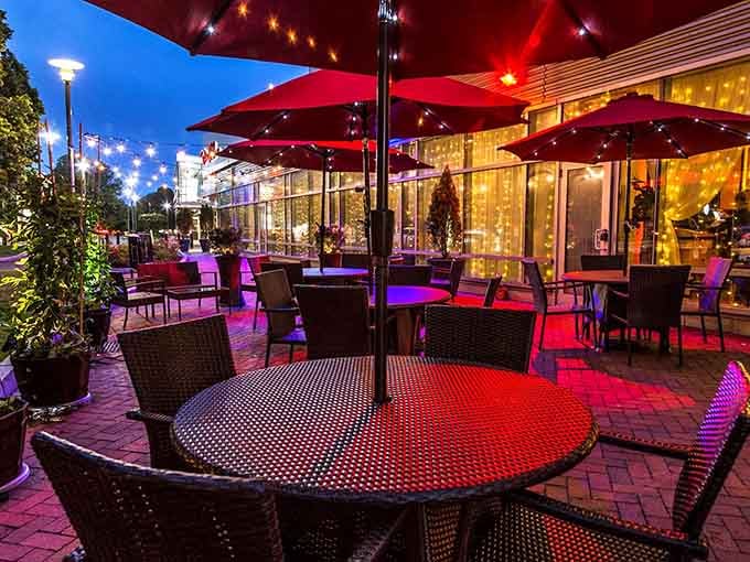 This glowing patio at twilight with red umbrellas creates the perfect setting for lingering over dinner and conversation.