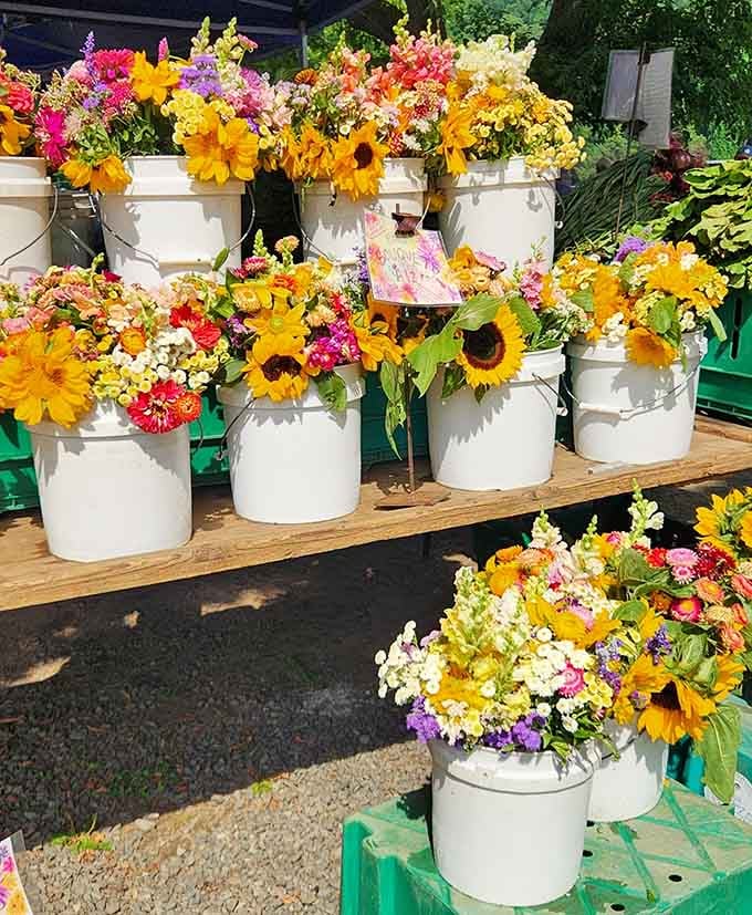 Fresh flowers in white buckets bring natural beauty to a market already bursting with colorful discoveries.