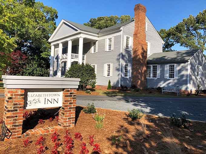 The Elizabethtown Inn's white columns and brick entrance exude classic Southern charm, promising restful nights in elegant surroundings.