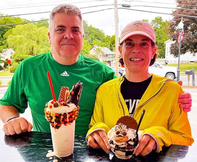 Happy customers clutching elaborate sundaes prove that ice cream and chocolate together create pure, photographic joy every single time.