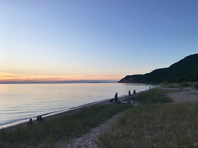 Families gathering along the shore as daylight fades, sharing the kind of simple moments that become cherished memories.