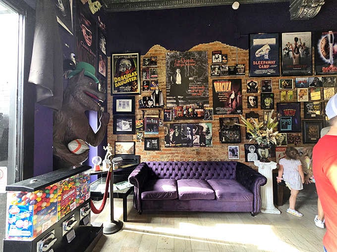 Purple velvet seating surrounded by classic horror posters creates an atmosphere that's equal parts cozy and creepy cool.