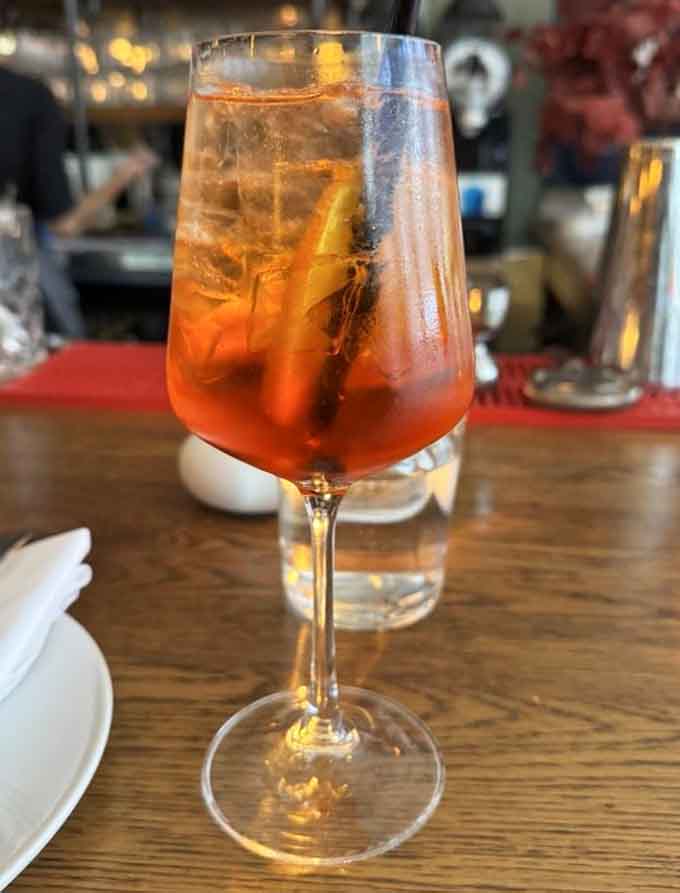 An Aperol spritz catches the light beautifully, the quintessential Italian aperitivo ready to start your evening right.