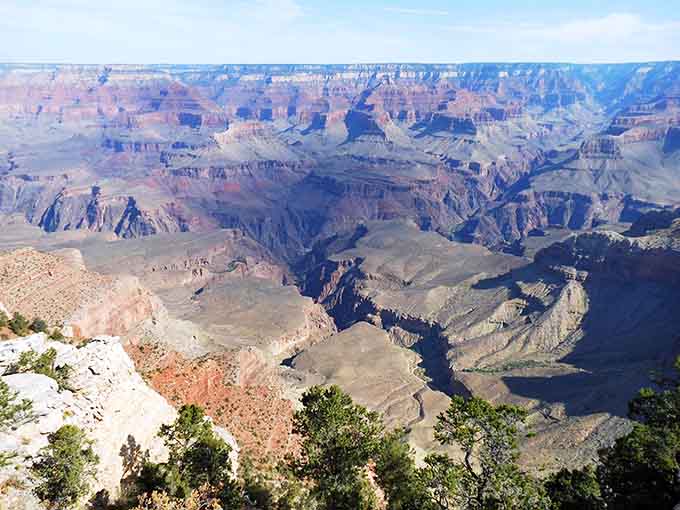 Shadows dance across ancient rock layers as the sun moves, creating an ever-changing masterpiece throughout the day.