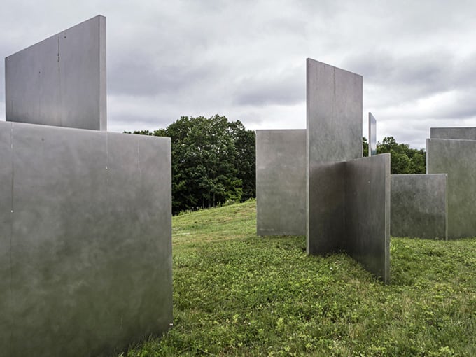 Concrete slabs rise from the earth like an architectural puzzle that challenges your perception of space itself.
