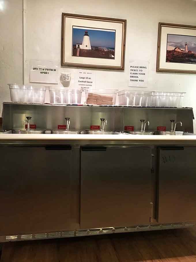 A self-serve sauce station with lighthouse art above—because every great seafood meal needs the perfect condiment companion.