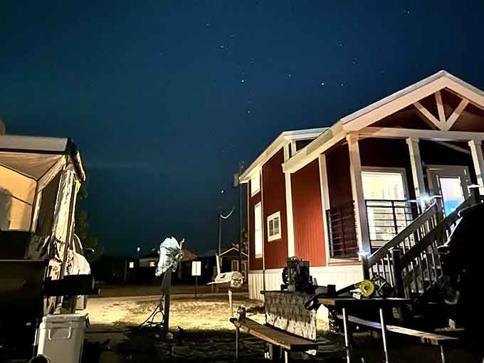 Stars blanket the night sky above cozy cabins, reminding you why unplugging from civilization feels so right.