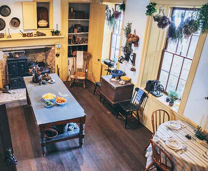 The period kitchen with its cast-iron stove and hanging herbs shows how families cooked before microwaves made us all lazy.