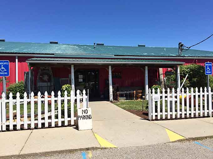 The cheerful red exterior and white picket fence welcome treasure hunters to begin their vintage shopping adventure immediately.