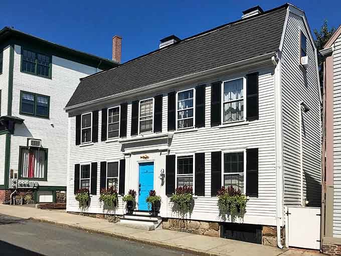 A turquoise door pops against white clapboard, proving colonial homes can absolutely pull off bold color choices.