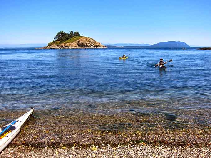 Kayakers heading out across impossibly clear water. This is what "getting away from it all" actually means.