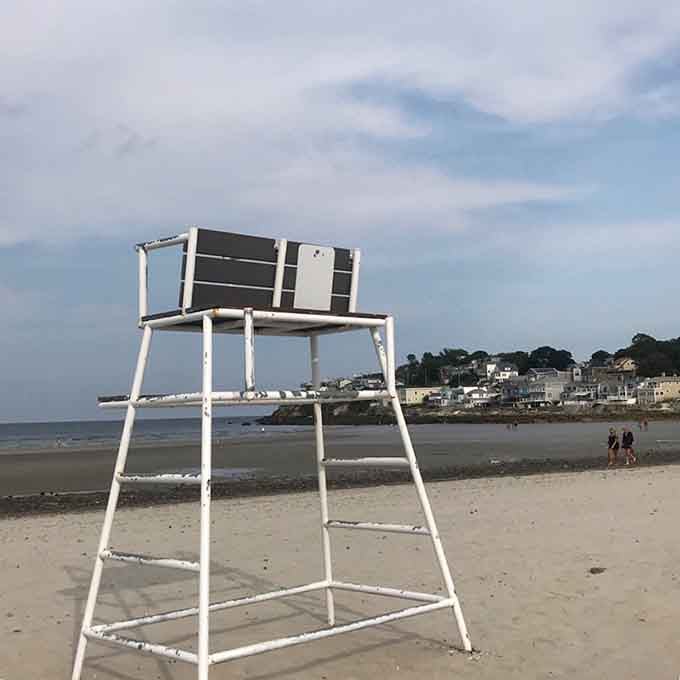 The lifeguard chair stands ready, a reassuring sentinel watching over summer fun and ocean adventures below.
