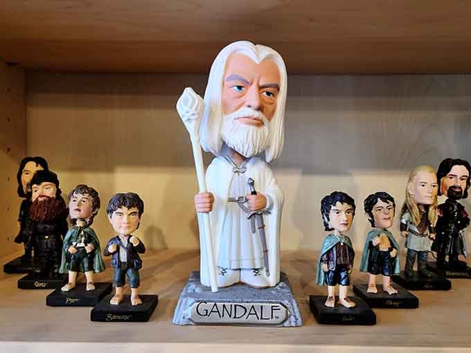 Gandalf towers over the Fellowship in bobblehead form, his wizardly wisdom now expressed through gentle head-wobbling instead of speeches.