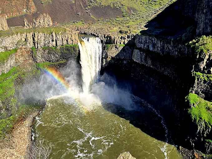 A rainbow arcs through the mist at Palouse Falls, because apparently this place needed to show off even more.