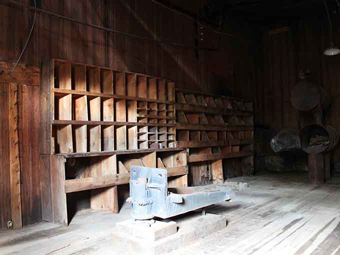 The machine shop's shelving system remains remarkably intact, organized chaos frozen in time for over a century.